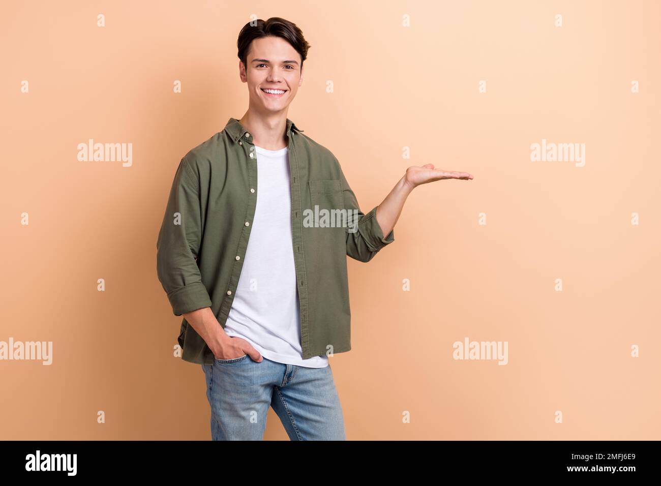 Portrait of positive friendly man hand palm hold demonstrate empty ...