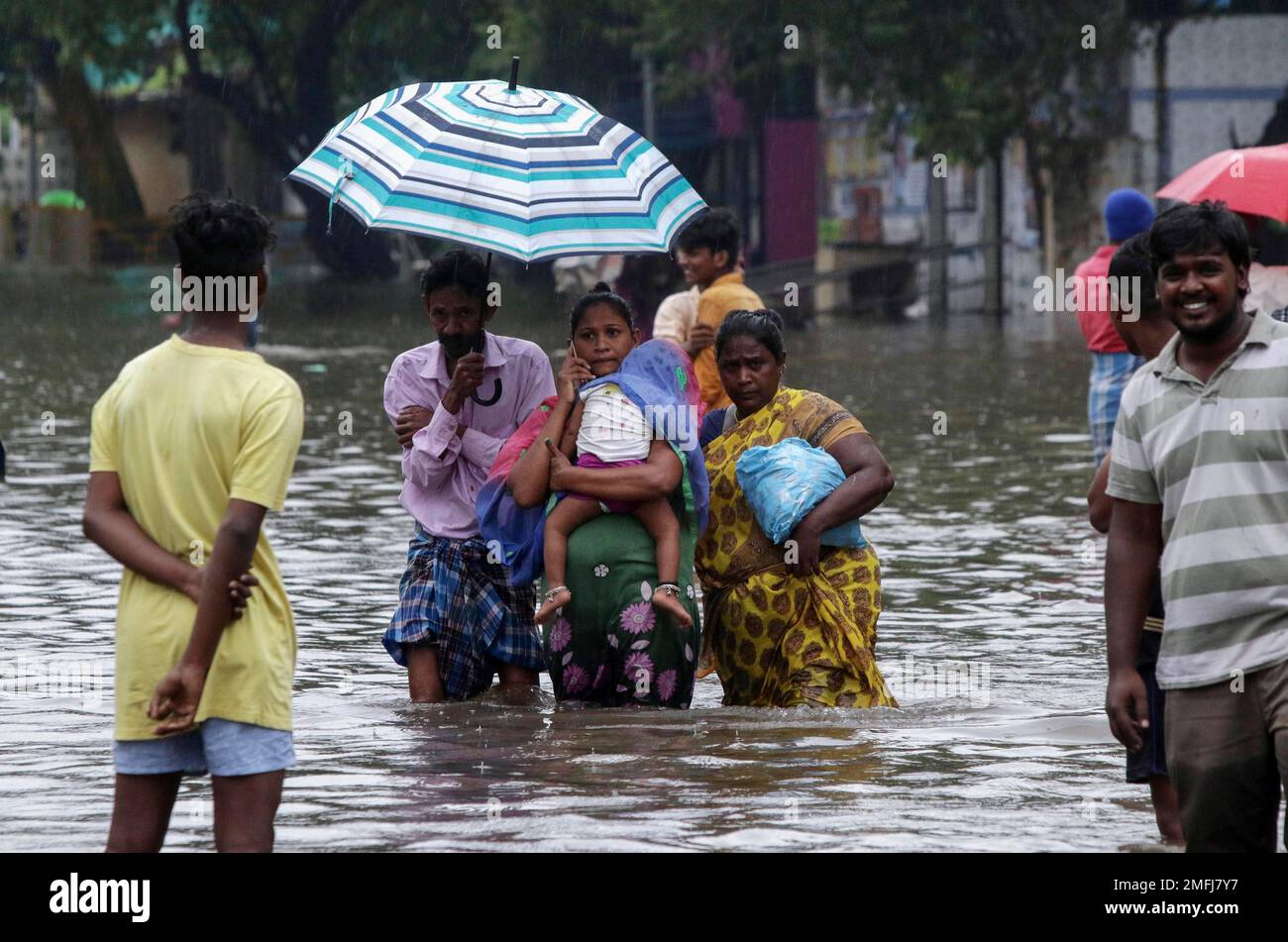 People wade through a flooded street in Chennai, India, Wednesday, Nov ...