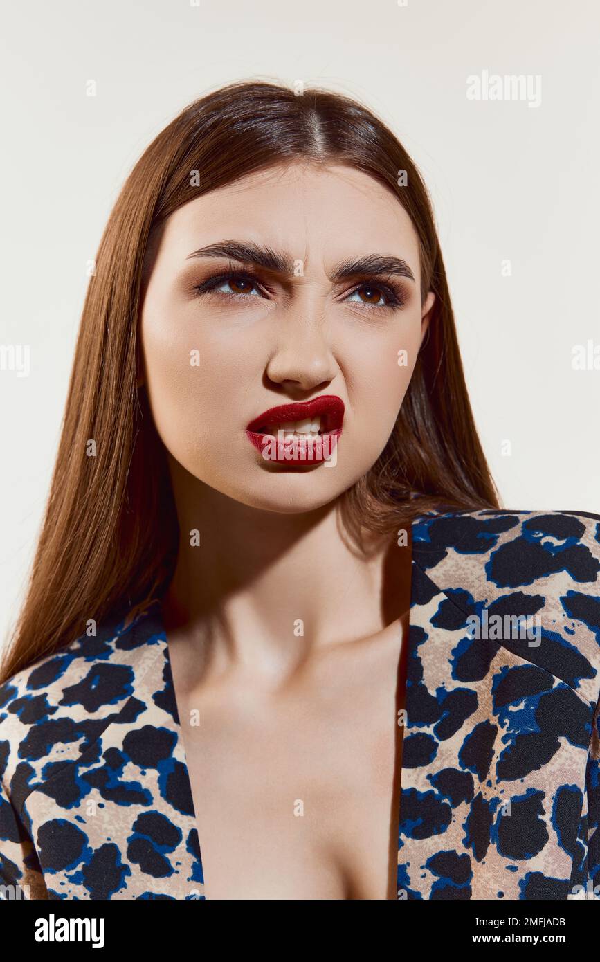 Grimacing. Young beautiful girl with straight brown hair and red lips ...