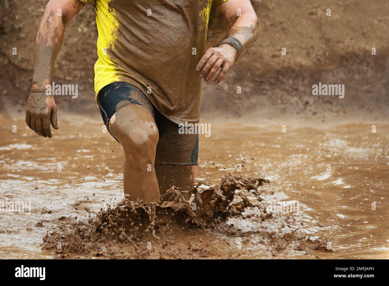 Mud race runners obstacle race runner in action Stock Photo - Alamy