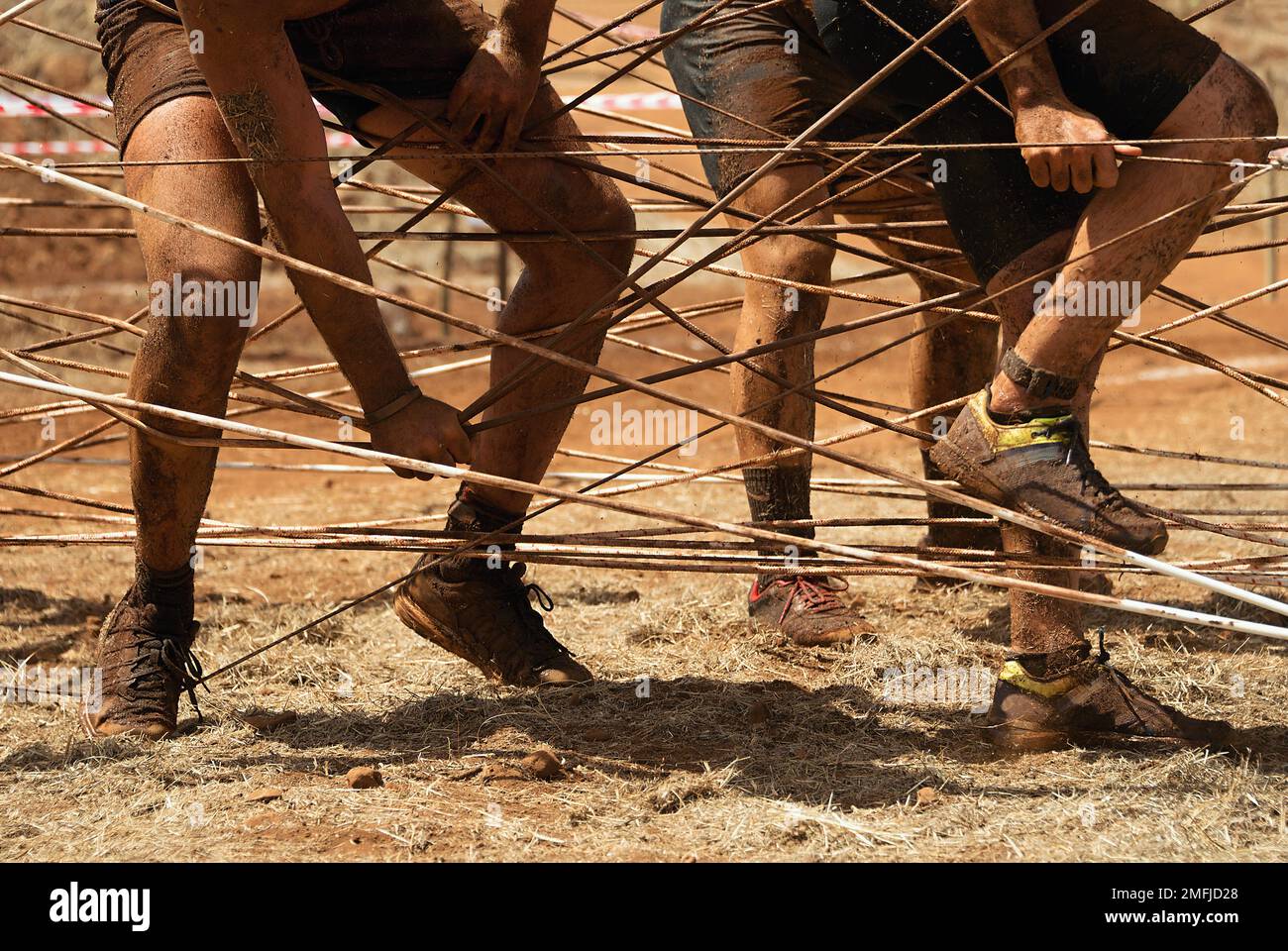 Mud race runners,racers overcome the obstacle from the ropes Stock ...