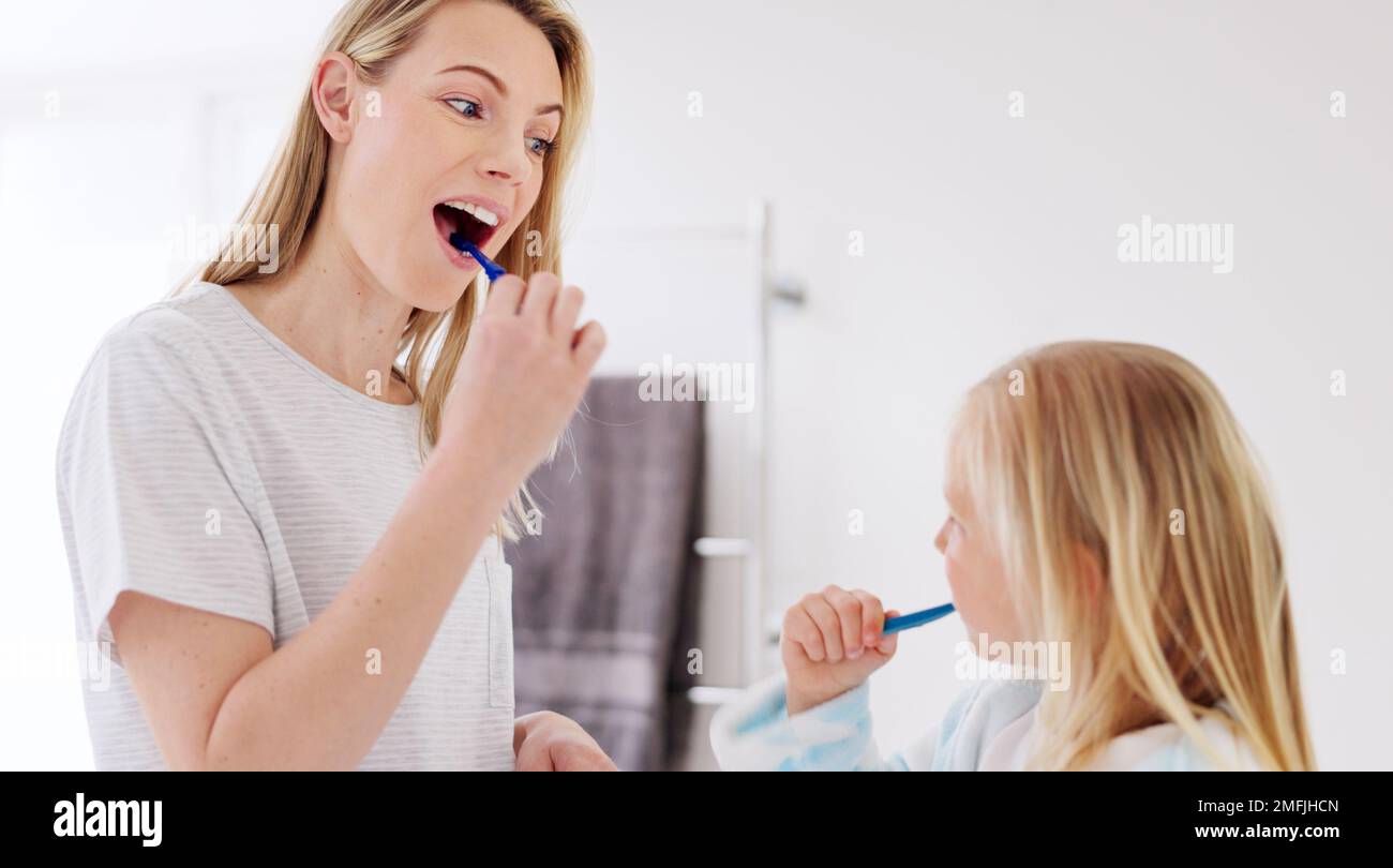 Toothbrush, mother and girl cleaning their teeth in the morning in the ...
