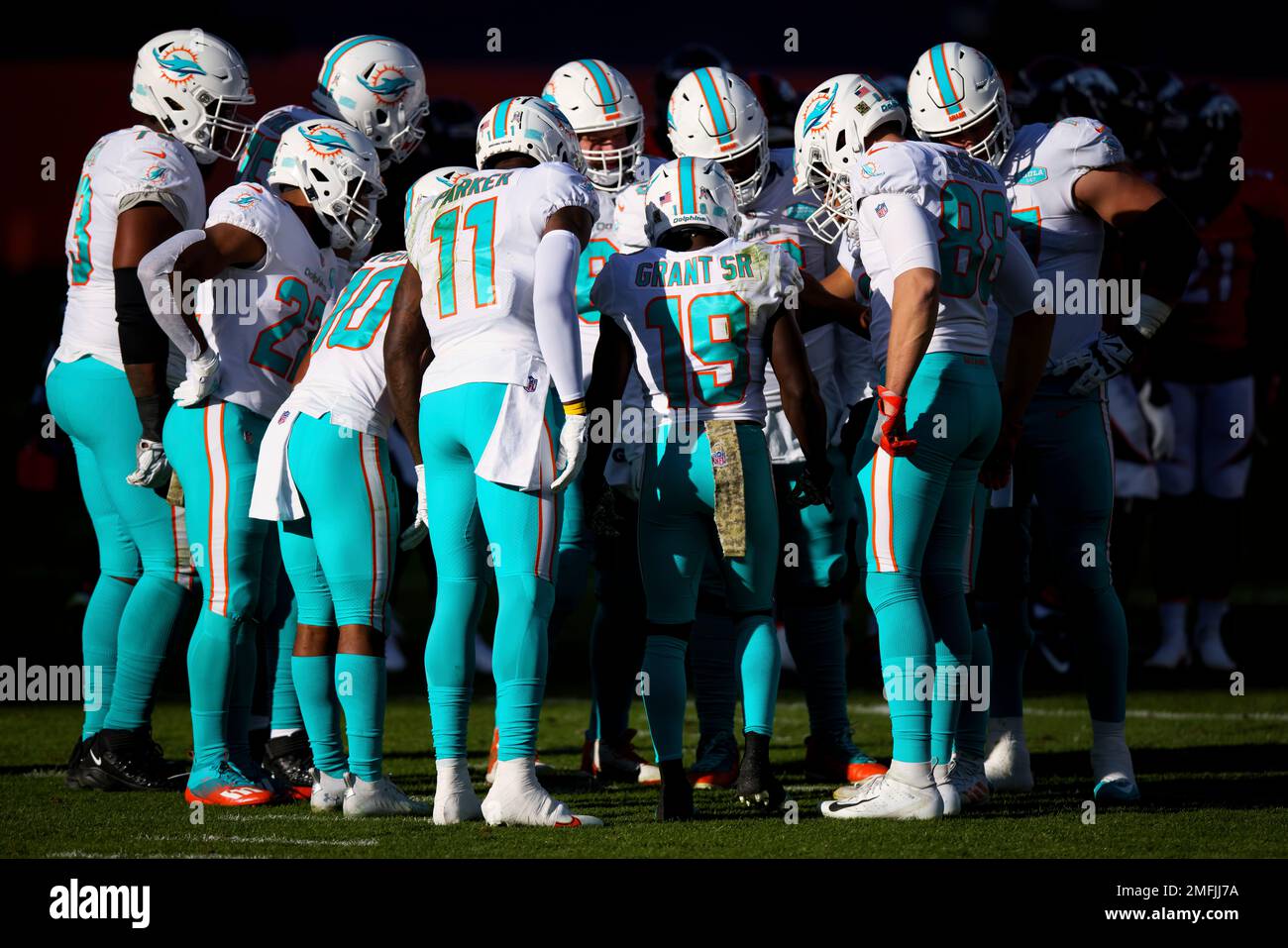The Miami Dolphins offense huddles against the Denver Broncos during ...