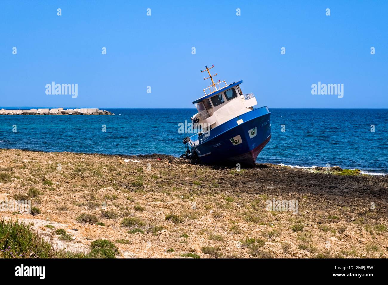 A stranded fishing boat lies on the beach of Marzamemi Stock Photo - Alamy