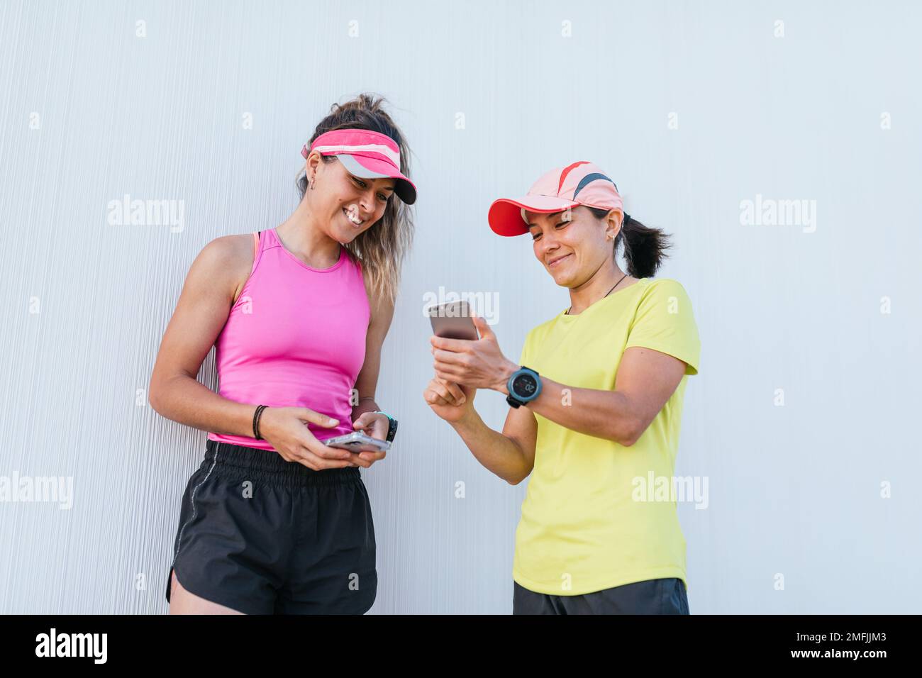 Two girls with their smart phones for a date. Valentine's Day. Concept ...