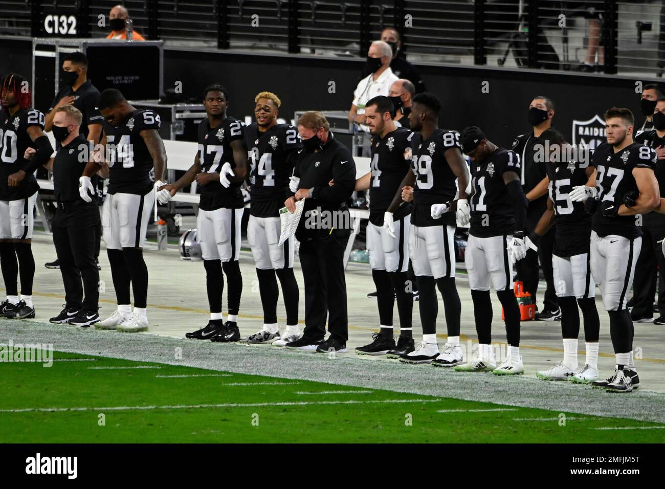 Las Vegas Raiders players stand during the national anthem before an ...
