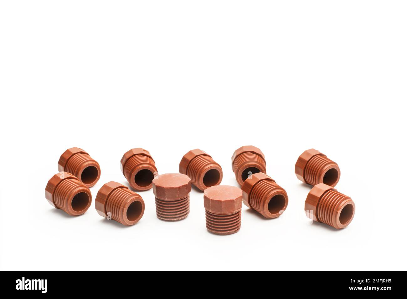 Brown plastic plugs for water pipes on a white background with copy ...