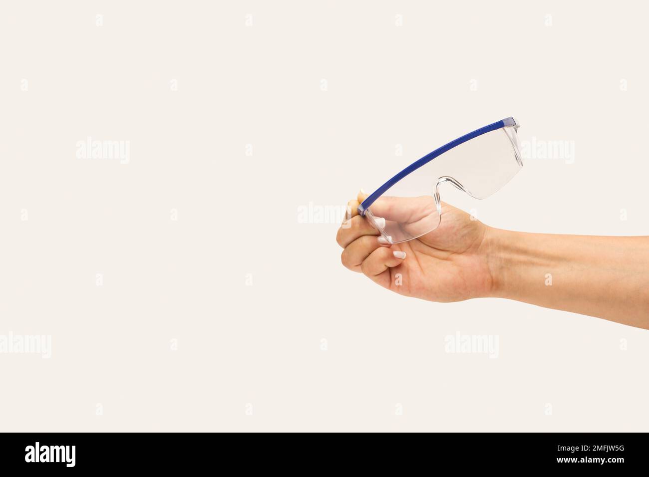 Woman hand holding protection transparent eye glasses on a white ...