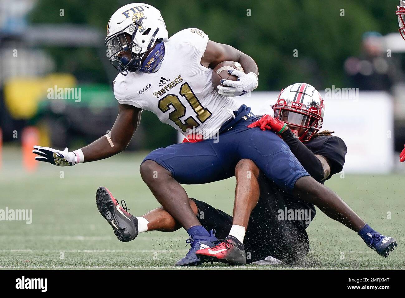 Florida International running back EJ Wilson Jr. (21) is tackled by ...