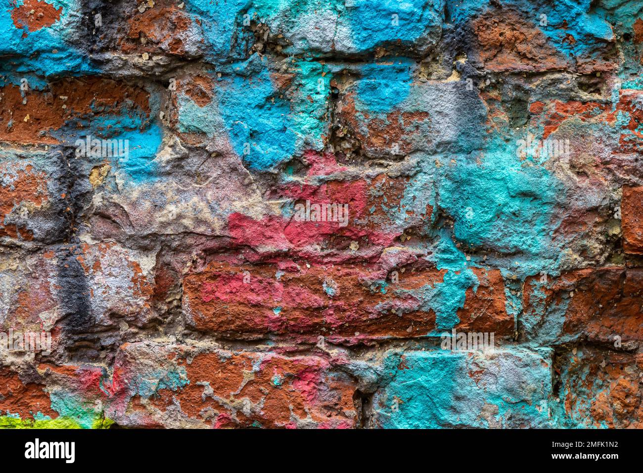 Brick wall with multi-colored paint close-up. Background brick creative ...