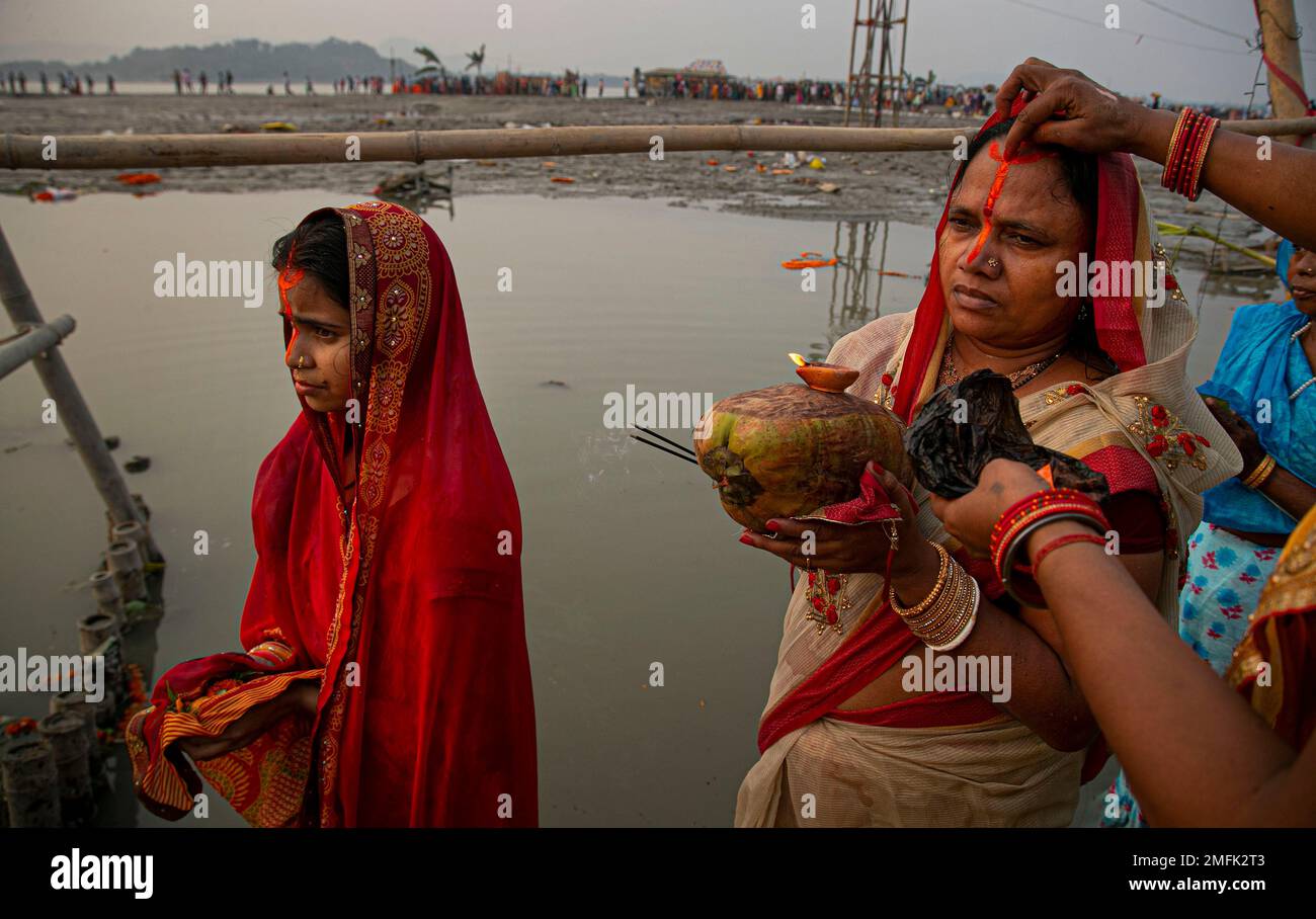 An Indian woman applies vermilion paste on another while performing ...