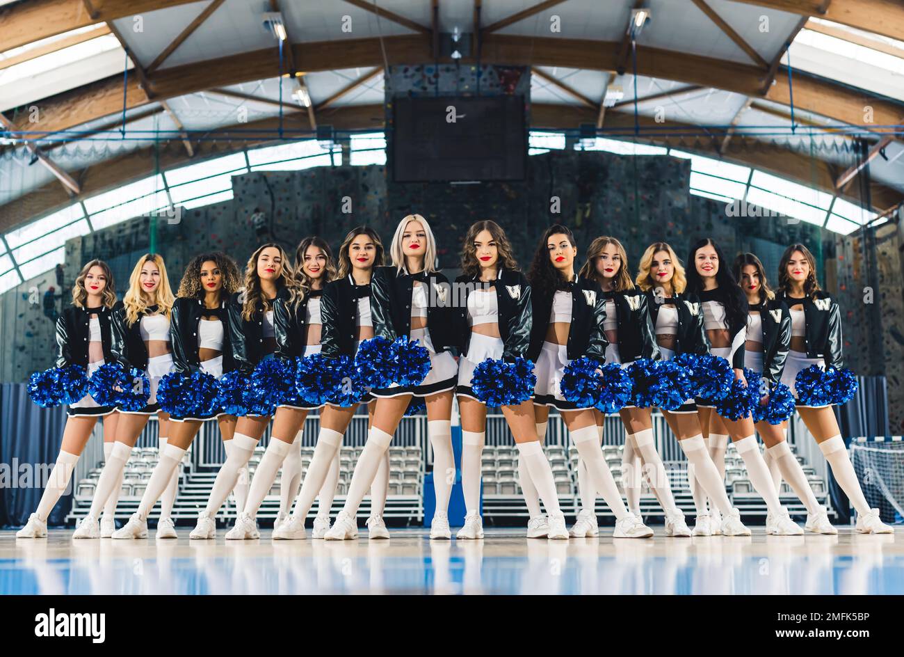 Front view of female group of cheerleaders standing in v formation in ...