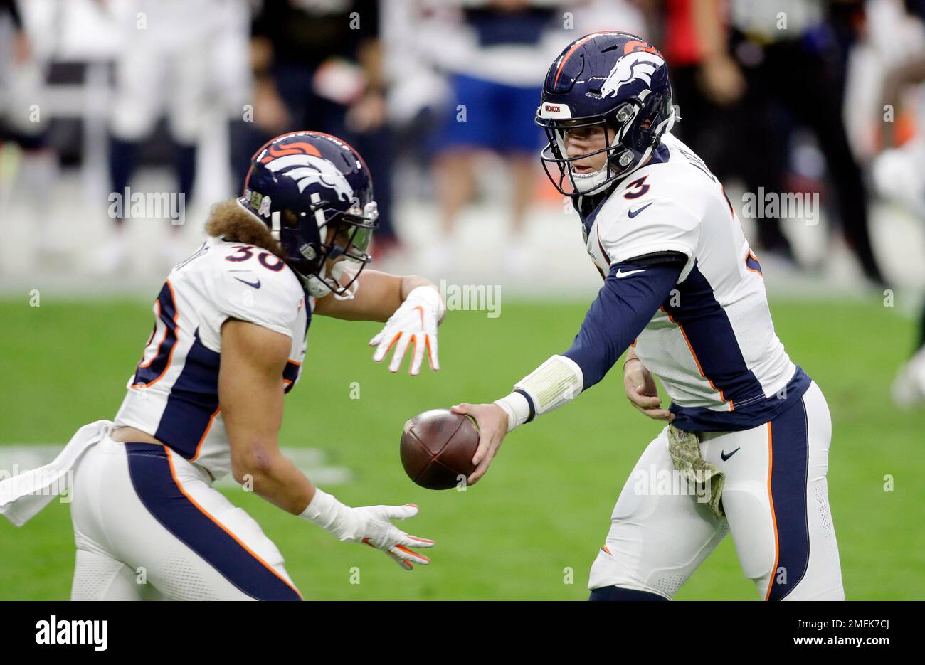 Denver Broncos quarterback Drew Lock (3) hands off to running back ...