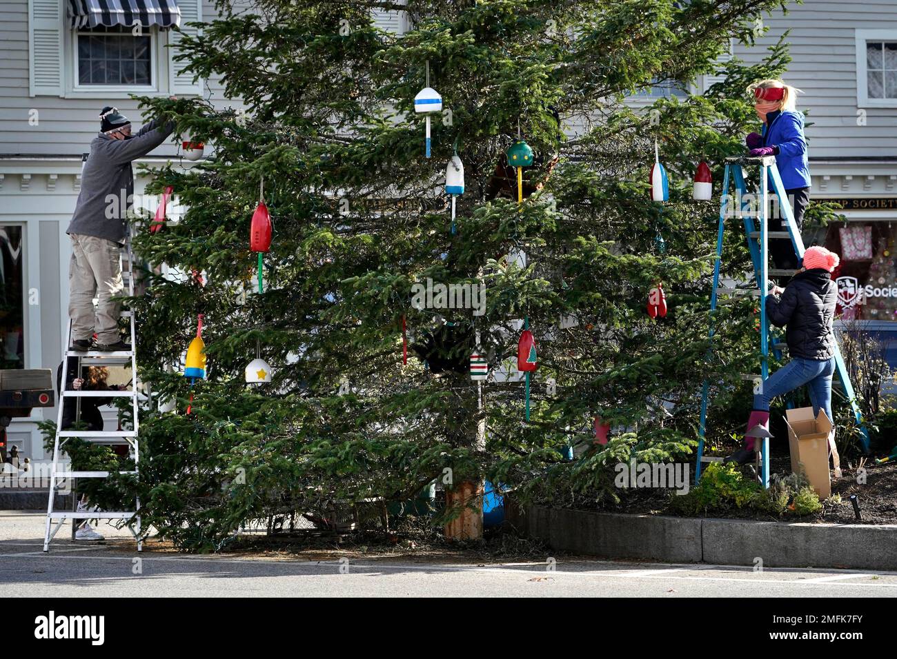 Tim Ames, left, and Tina Hewett-Gordon, use ladders to hangs ornaments ...
