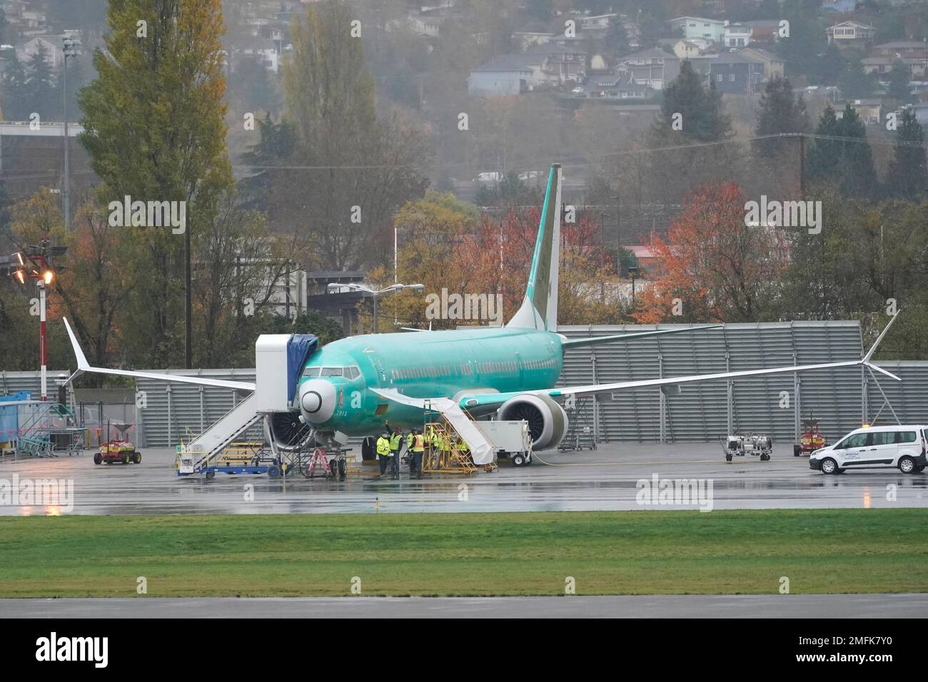 Workers stand near a Boeing 737 Max airplane parked at Renton Municipal ...
