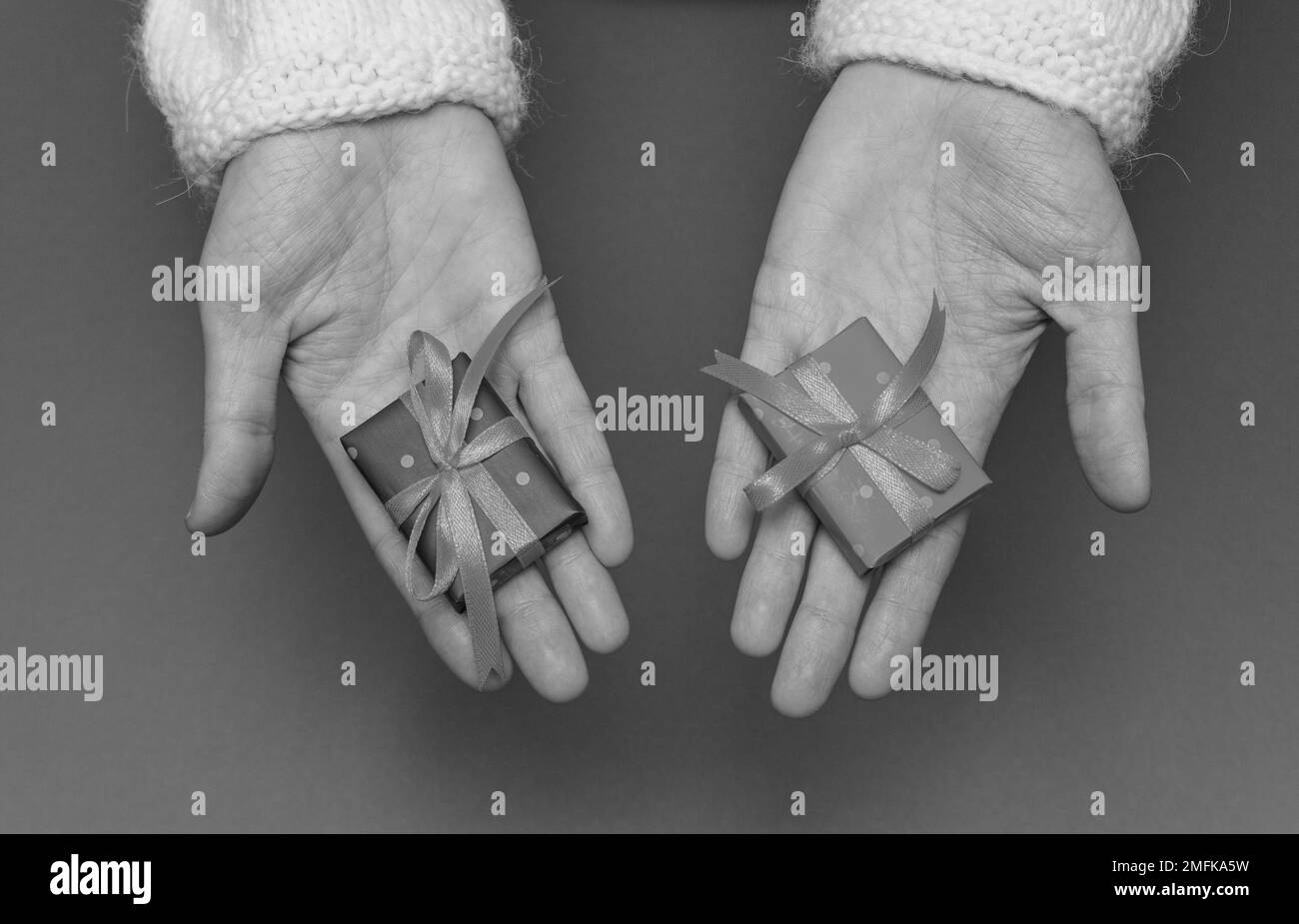 Person holds in her hands gift boxes in color paper as a present in ...