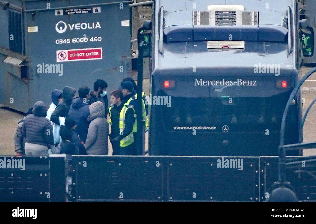 A group of people thought to be migrants are boarded on a coach at the ...