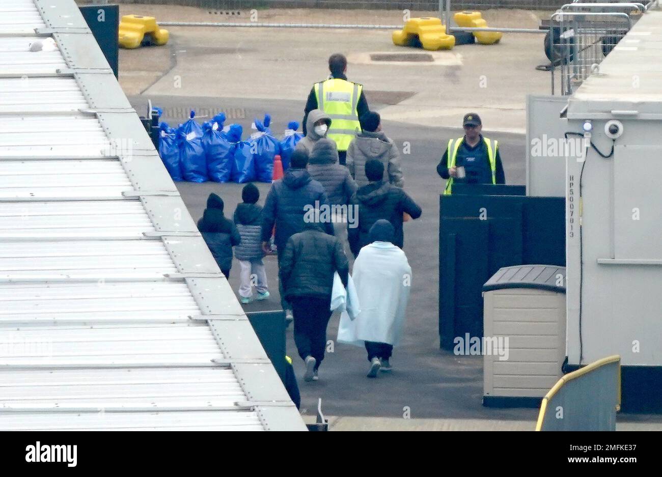 A group of people thought to be migrants are lead through the ...