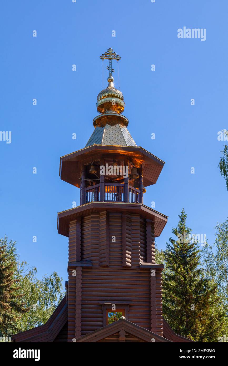 Wooden belfry of an Orthodox church with a gilded roof and a cross ...