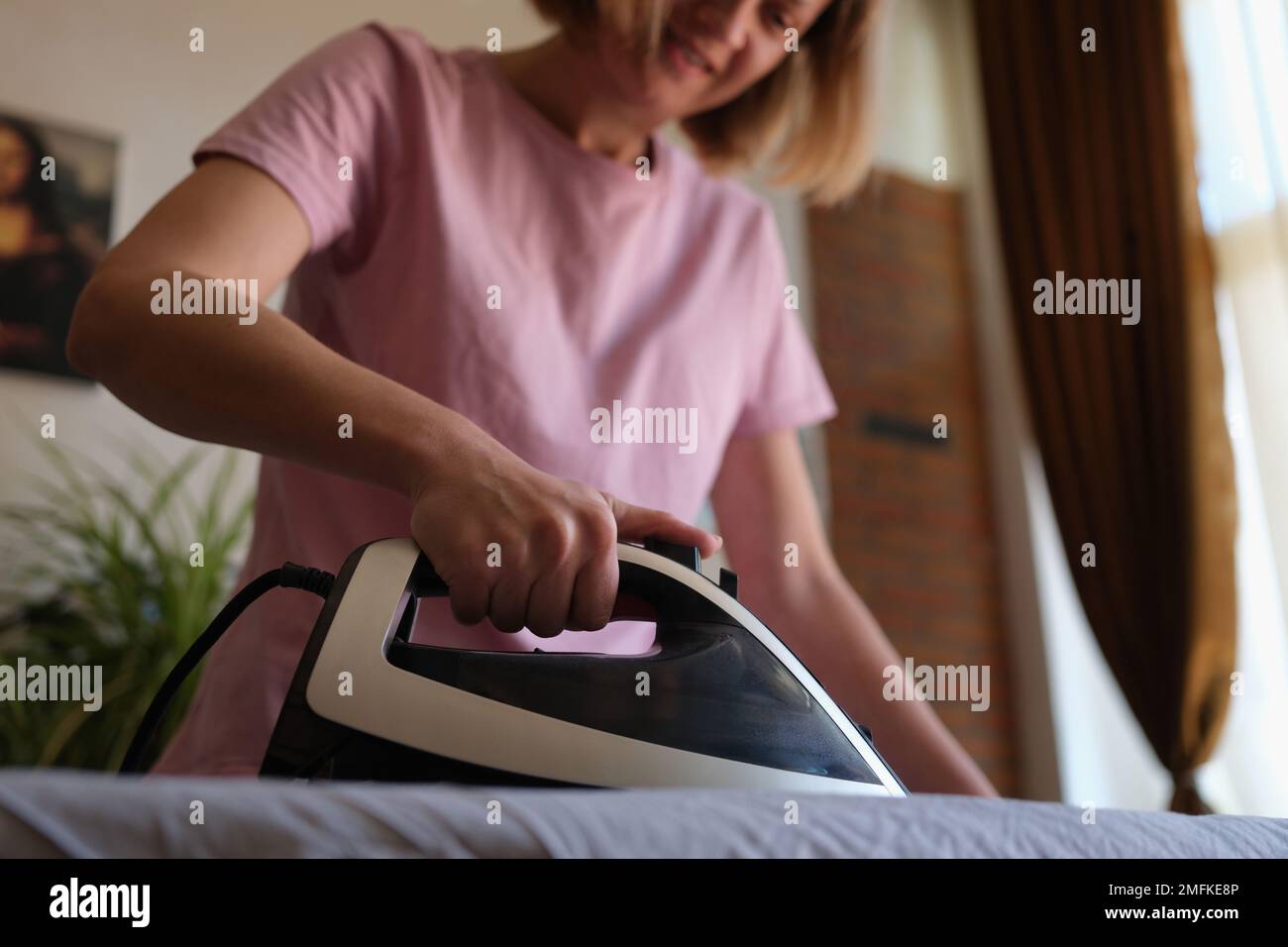 Woman ironing clothes at home on ironing board Stock Photo - Alamy