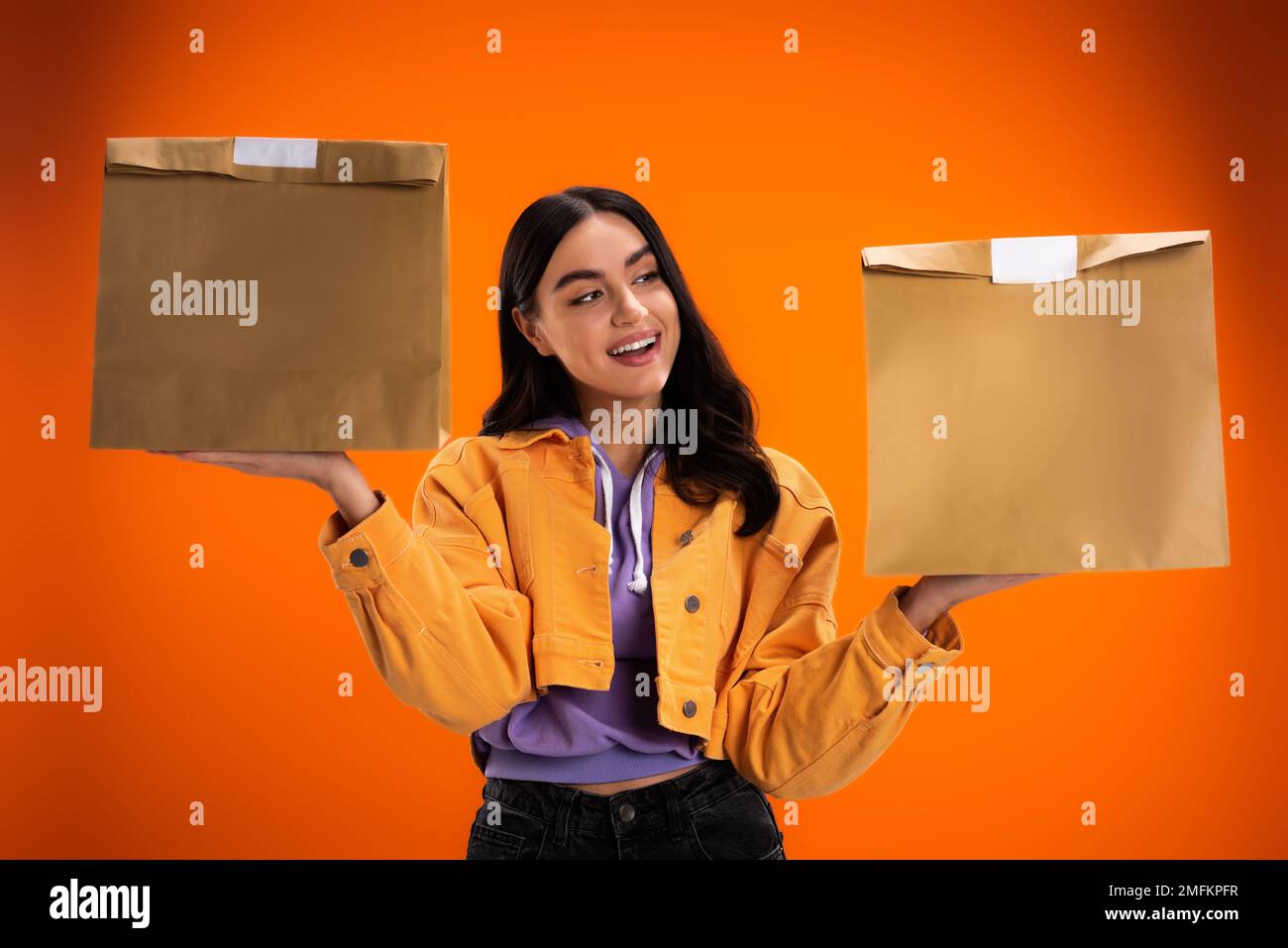 Positive Young Woman Holding Paper Bags From Food Delivery Isolated On