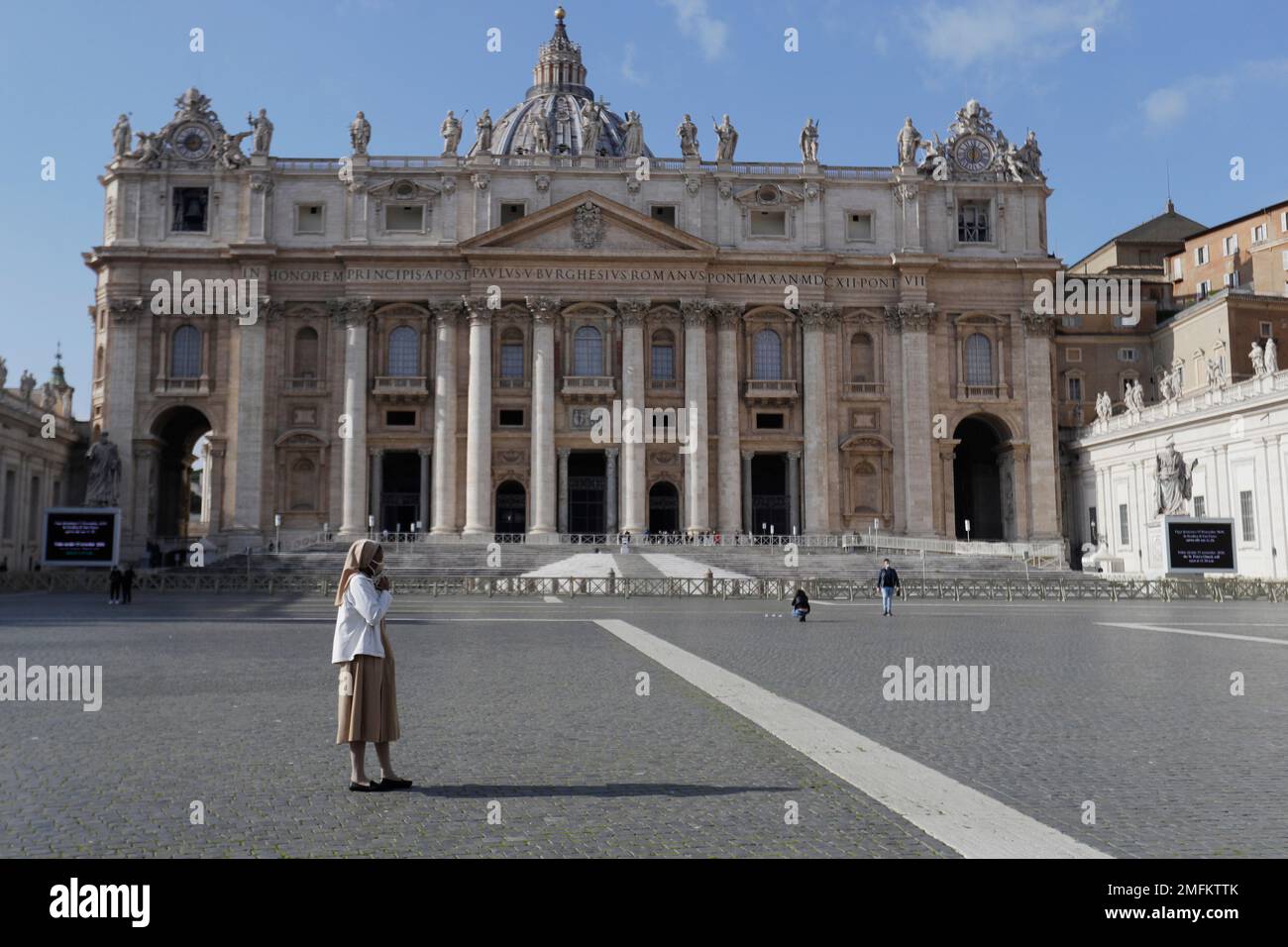 A nun stand praying as Pope Francis recites the Angelus prayer from his ...