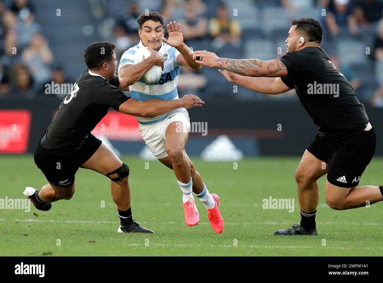 Argentina's Santiago Carreras, centre, runs at New Zealand's Anton ...