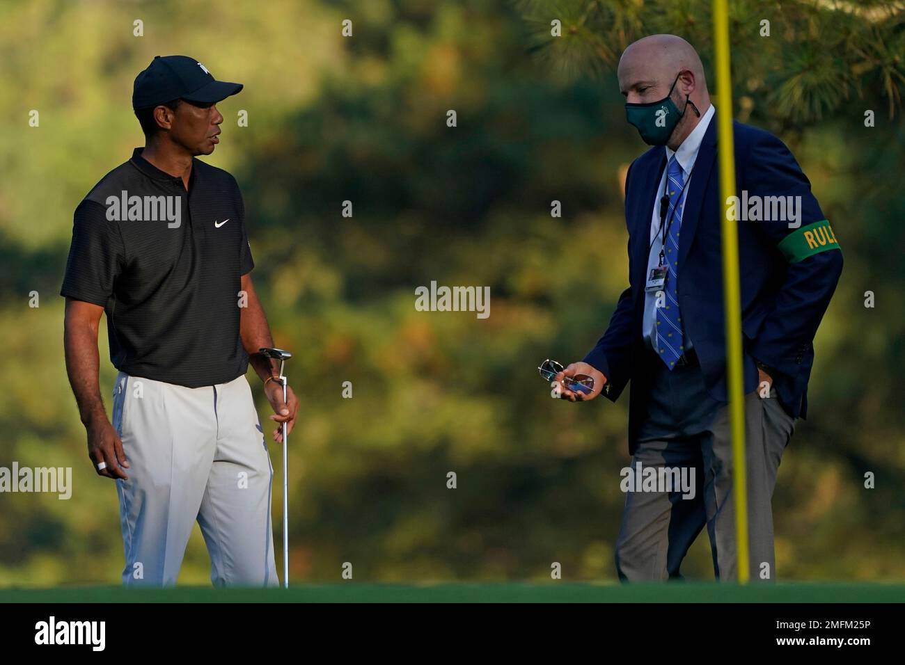 Tiger Woods speaks to a rules official before putting on the sixth ...