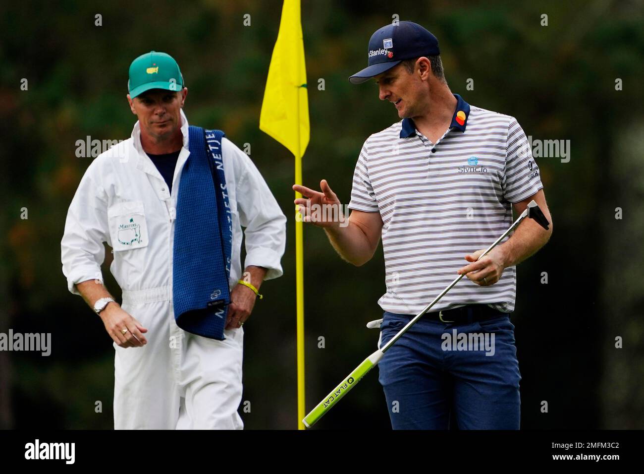 Justin Rose, of England, speaks to his caddie Gareth Bryn Lord after ...