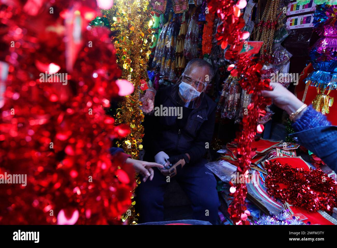 A Nepalese vendor sells plastic decorative flowers at the Ason market ...