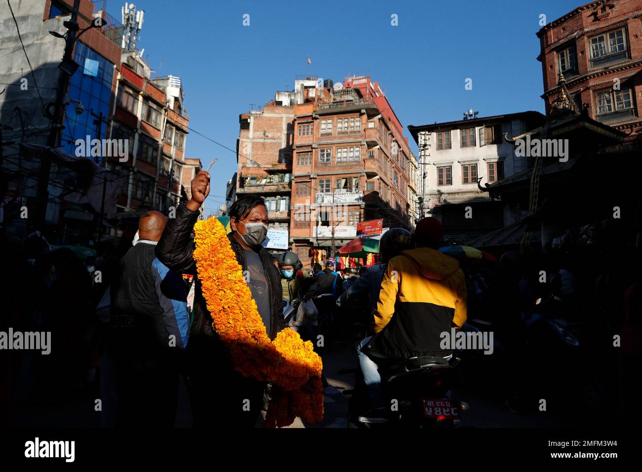 A Nepalese street vendor displays marigold flowers at the Ason market ...