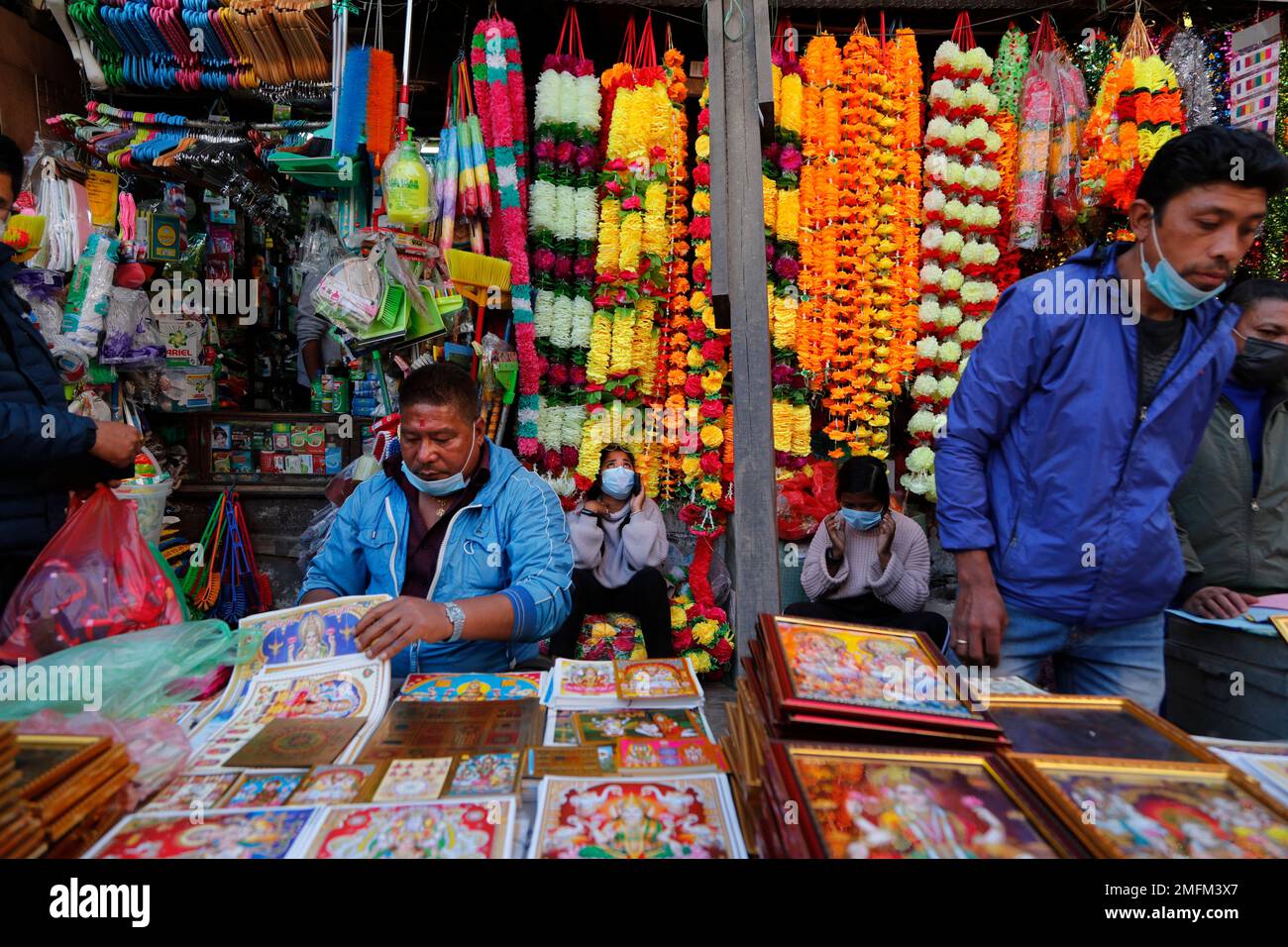 A Nepalese vendor sells plastic decorative flowers at the Ason market ...