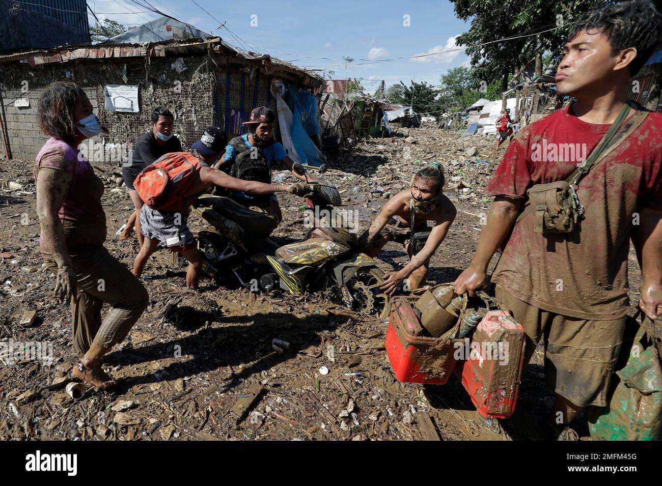 Residents retrieve their belongings at the typhoon-damaged Kasiglahan ...