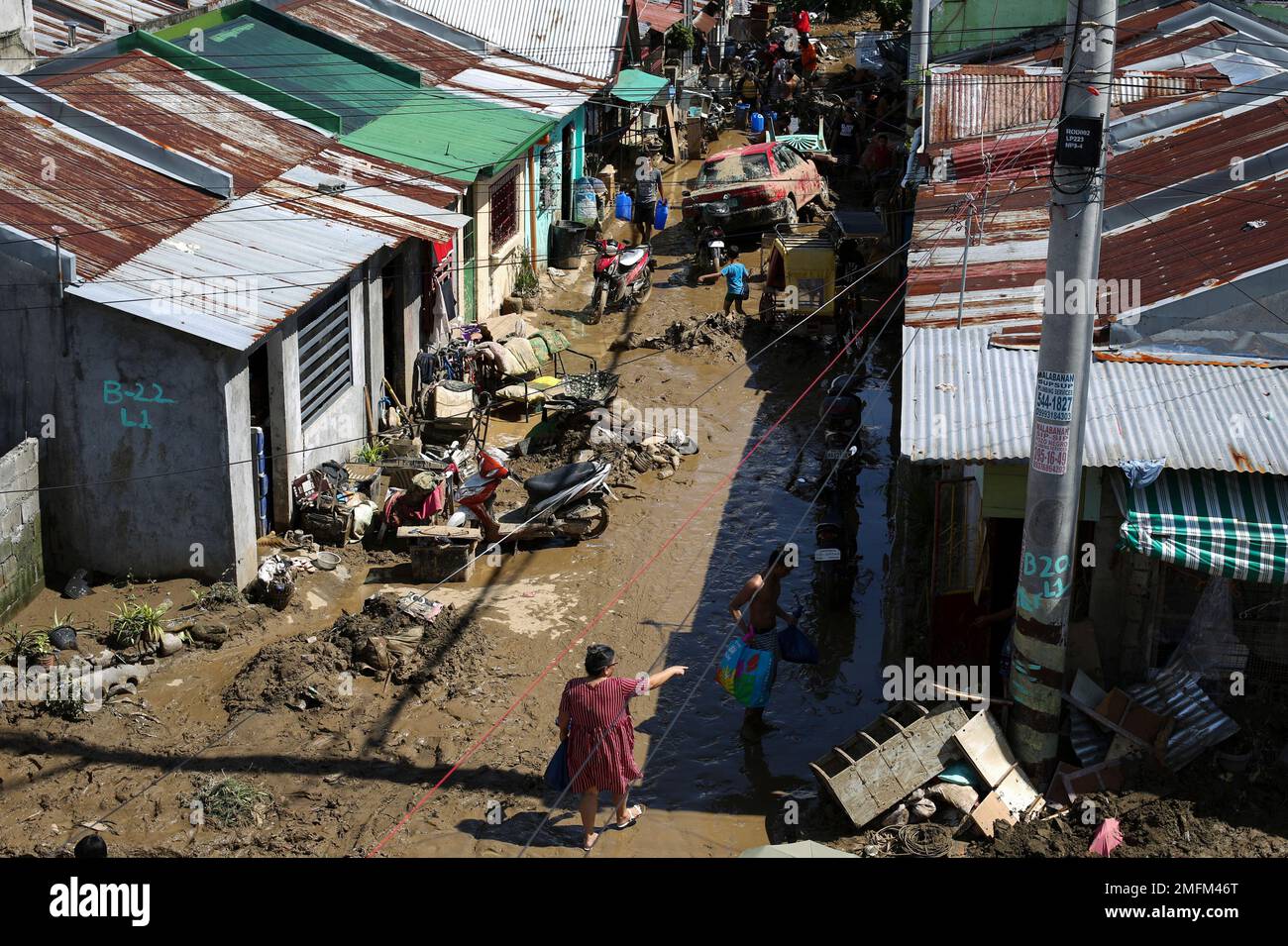 Residents return to their homes at the typhoon-damaged Kasiglahan ...