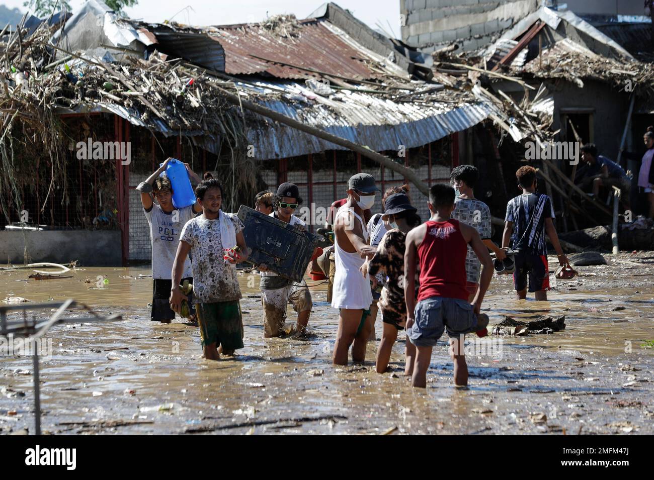 Residents carry belongings from their homes at the typhoon-damaged ...