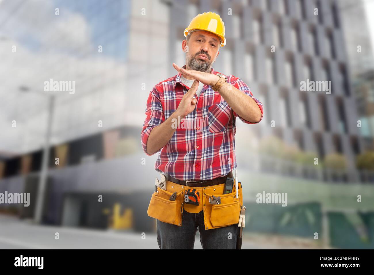 Tired worker making time-out gesture with one hand on top of another ...