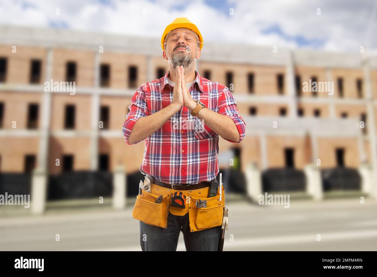 Worker making praying gesture with hands as faith and hope concept ...