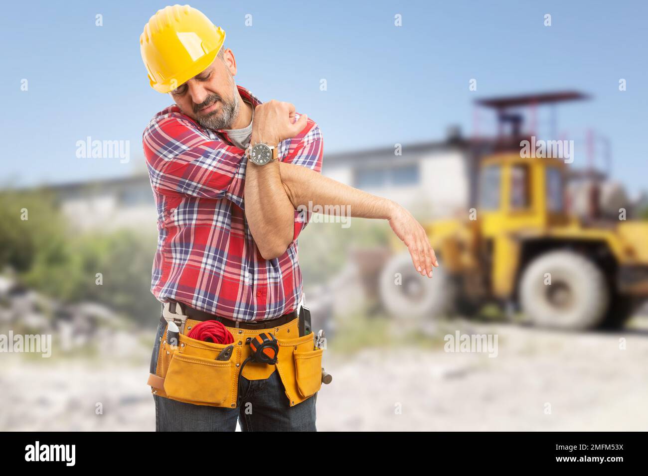 Tired male worker stretching his arms at workplace after hard work ...