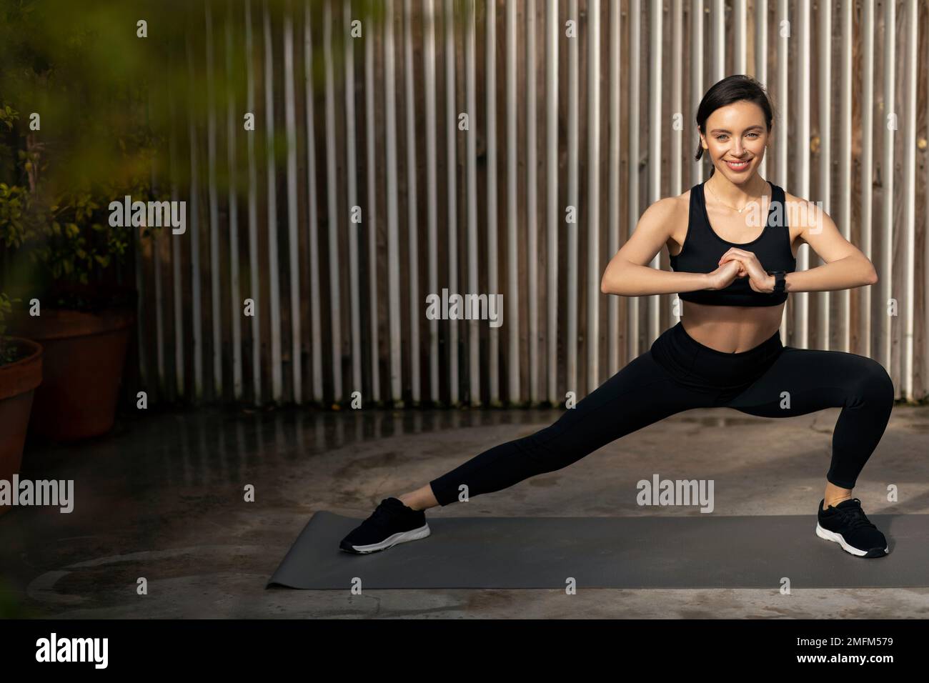 Happy muscular slim young european female athlete in sportswear doing ...