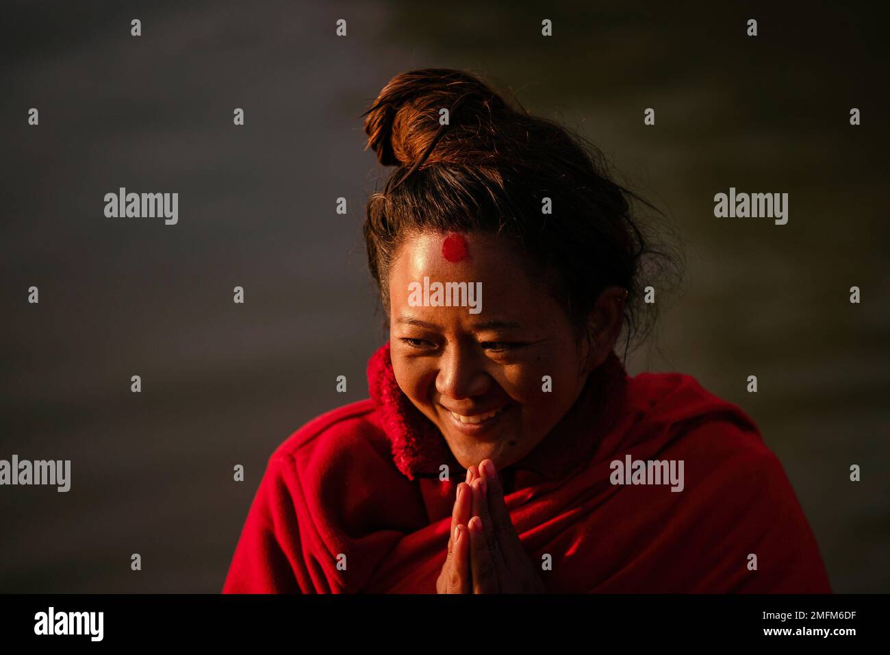 A Hindu devotee offers prayers next to the Triveni river during the ...