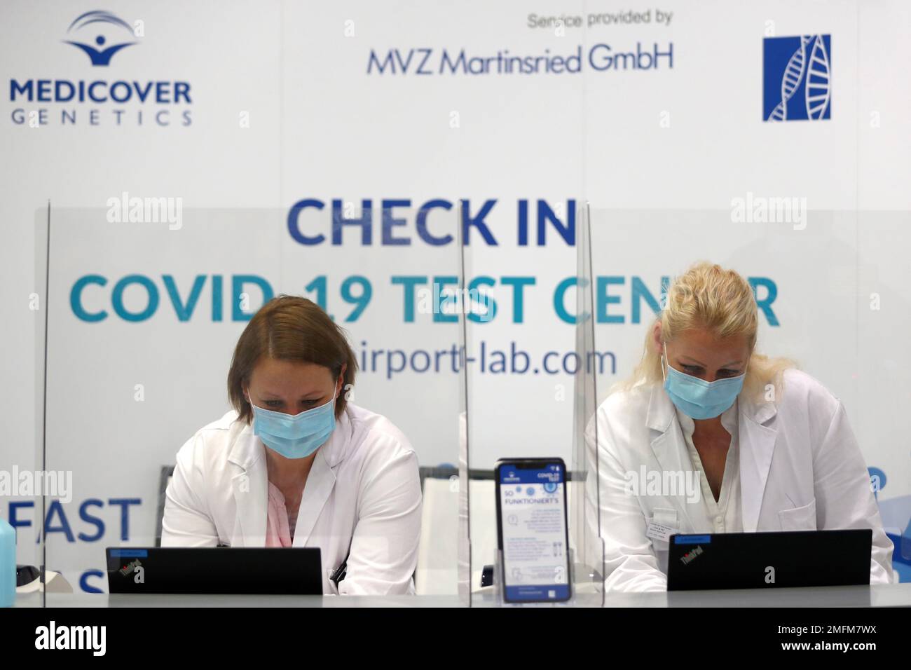 Employees of a new Lufthansa corona quick test center work behind a ...