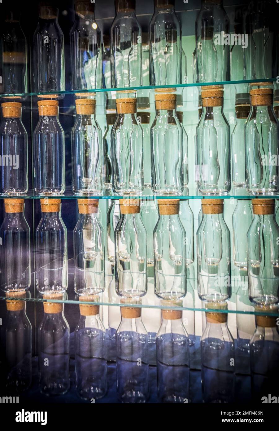 A decorative wall with rows of identical glass bottles Stock Photo - Alamy