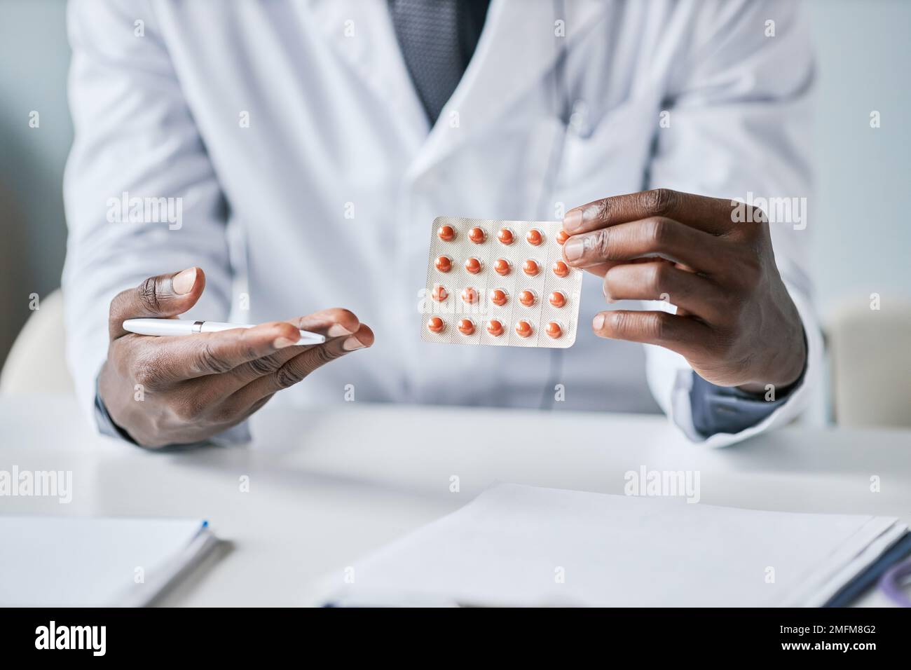 Close up of unrecognizable African American doctor holding tablets to ...