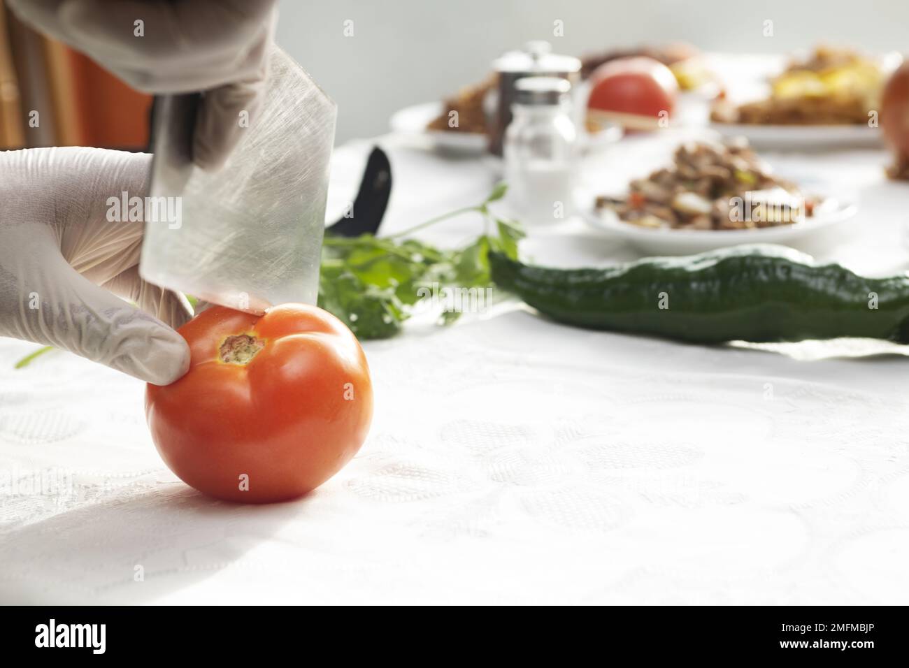 A chef with a large square knife cutting vegetables to add to some ...