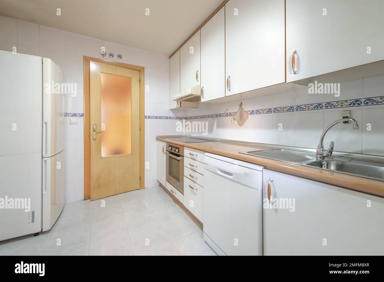 Modest kitchen with cheap flooring with built-in appliances and a ...