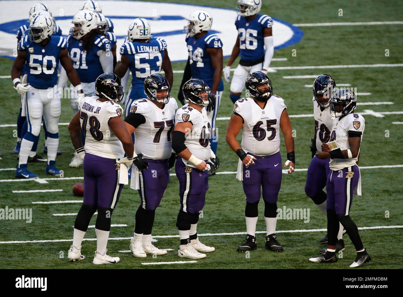The Baltimore Ravens and Indianapolis Colts huddle during an NFL ...