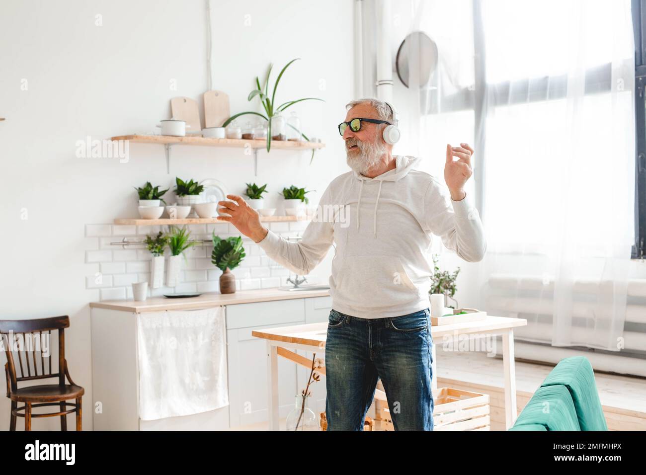 Happy senior man dancing while listening to music with headphones ...