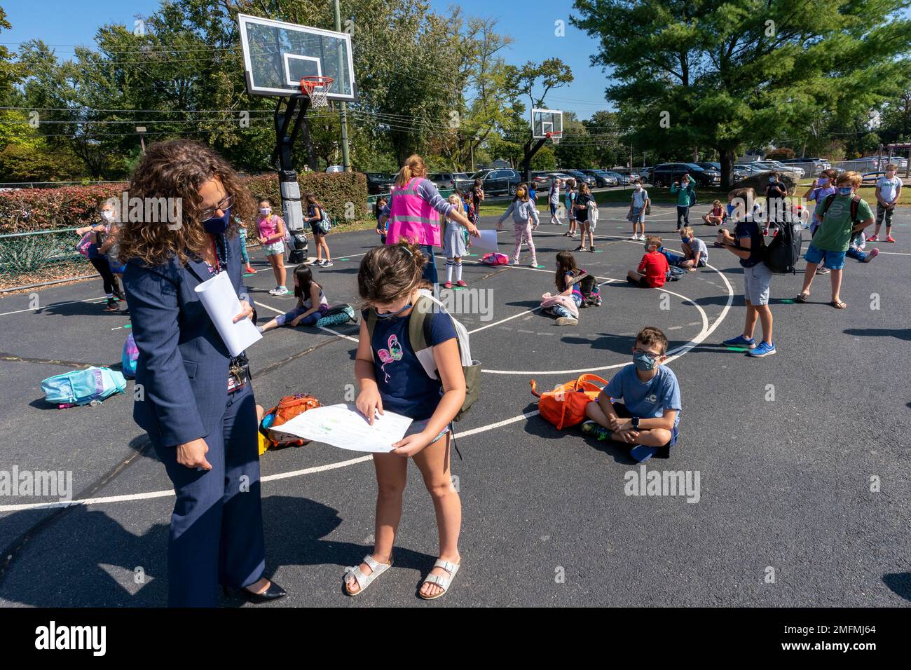 Principle Angela Garcia looks over a student's homework as children ...