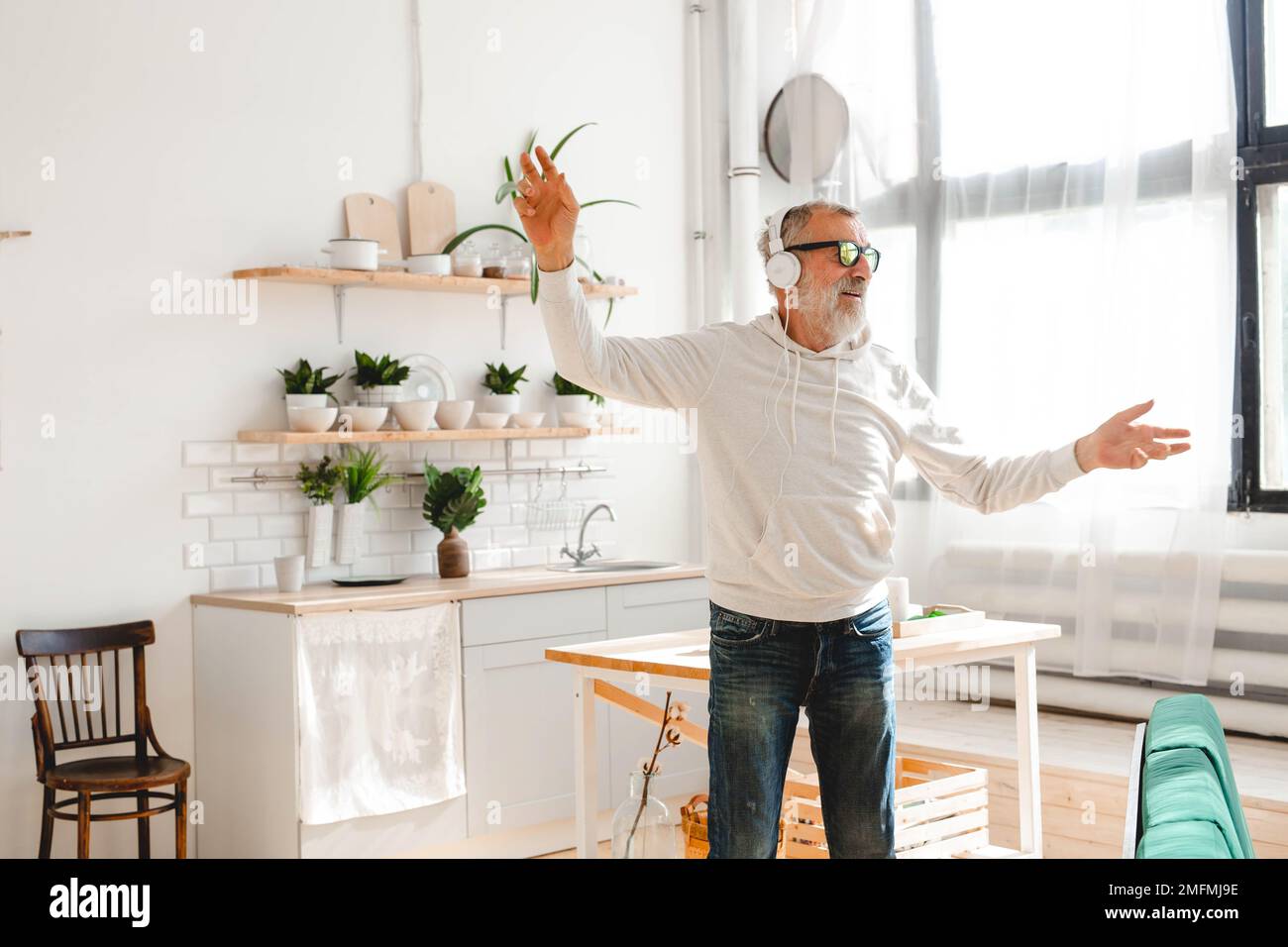 Happy senior man dancing while listening to music with headphones ...