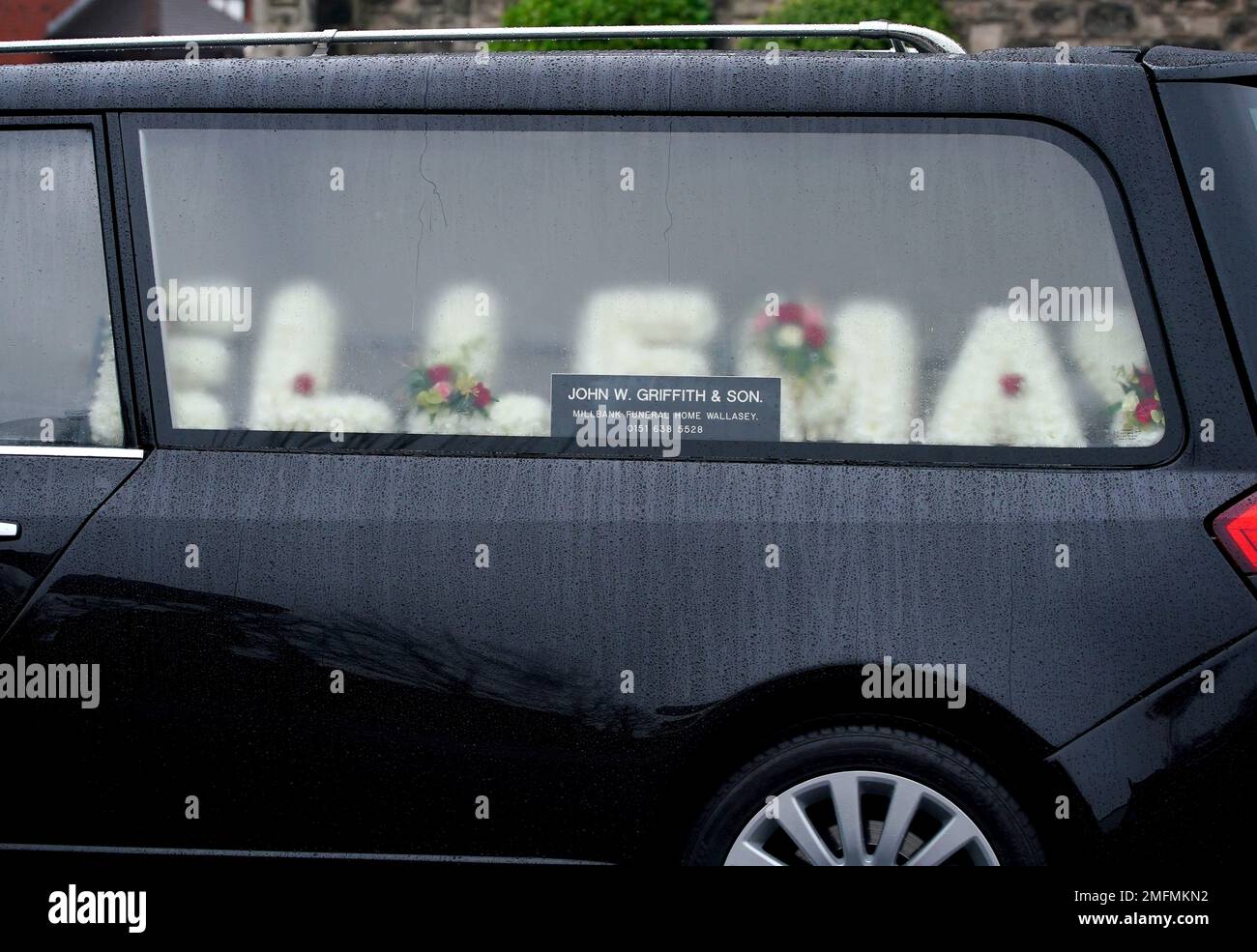 A floral tribute is transported in a hearse following the funeral ...